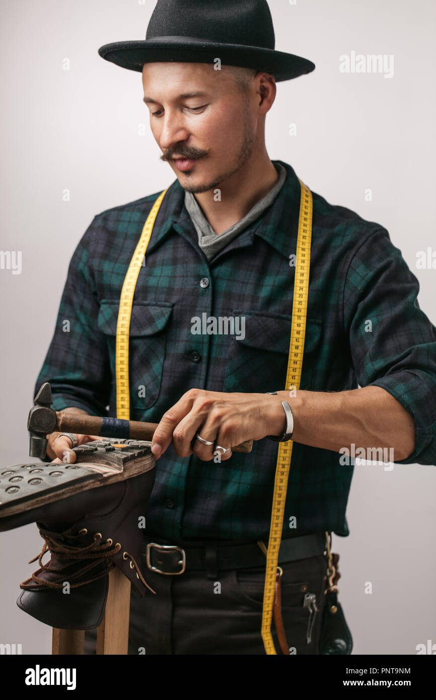 Shoemaker in studio. Unrecognizable shoemaker performs shoes in the ...