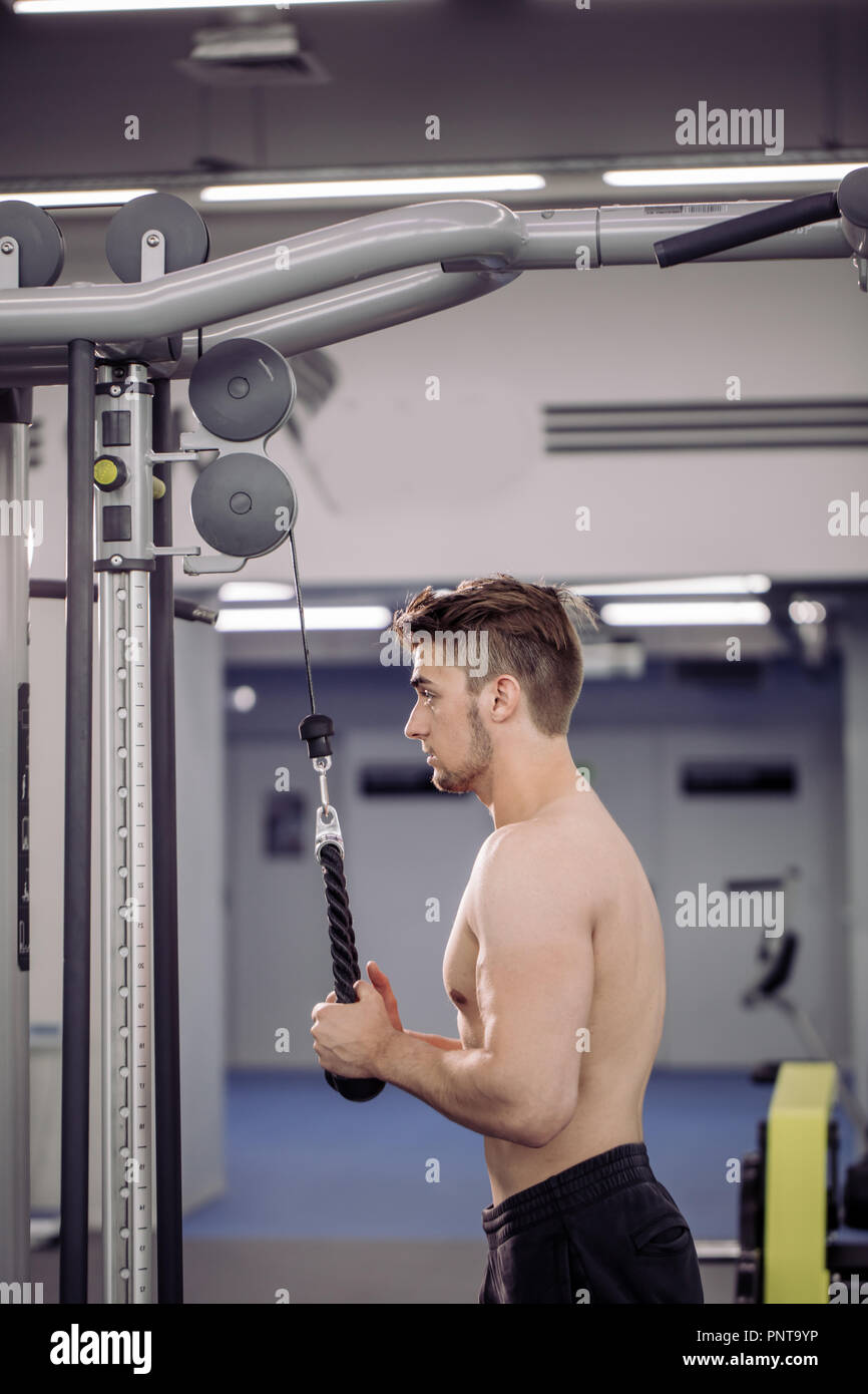 bodybuilder performing exercise with gym training mashine Stock Photo ...