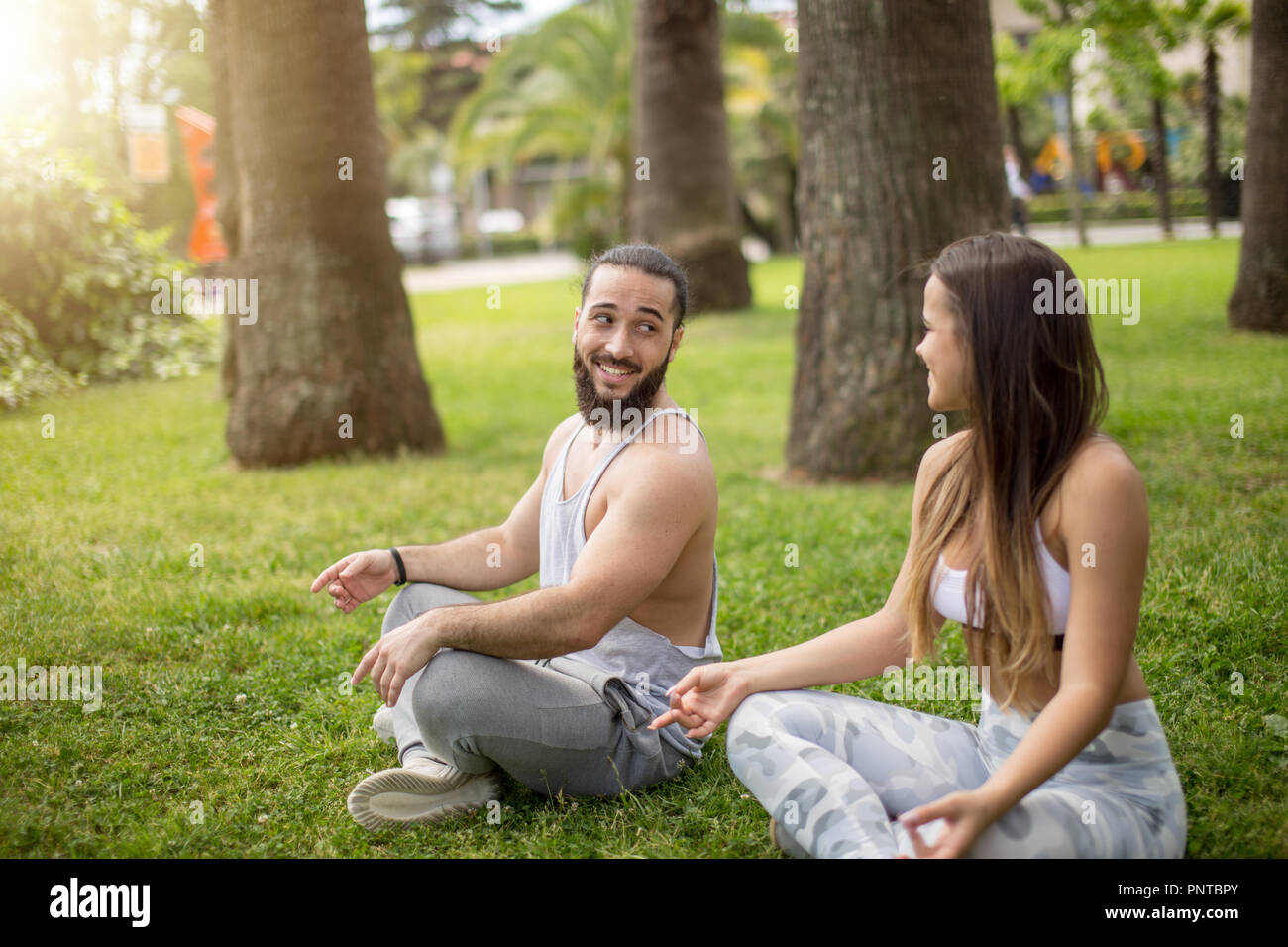 Young couple doing yoga outdoors Stock Photo - Alamy