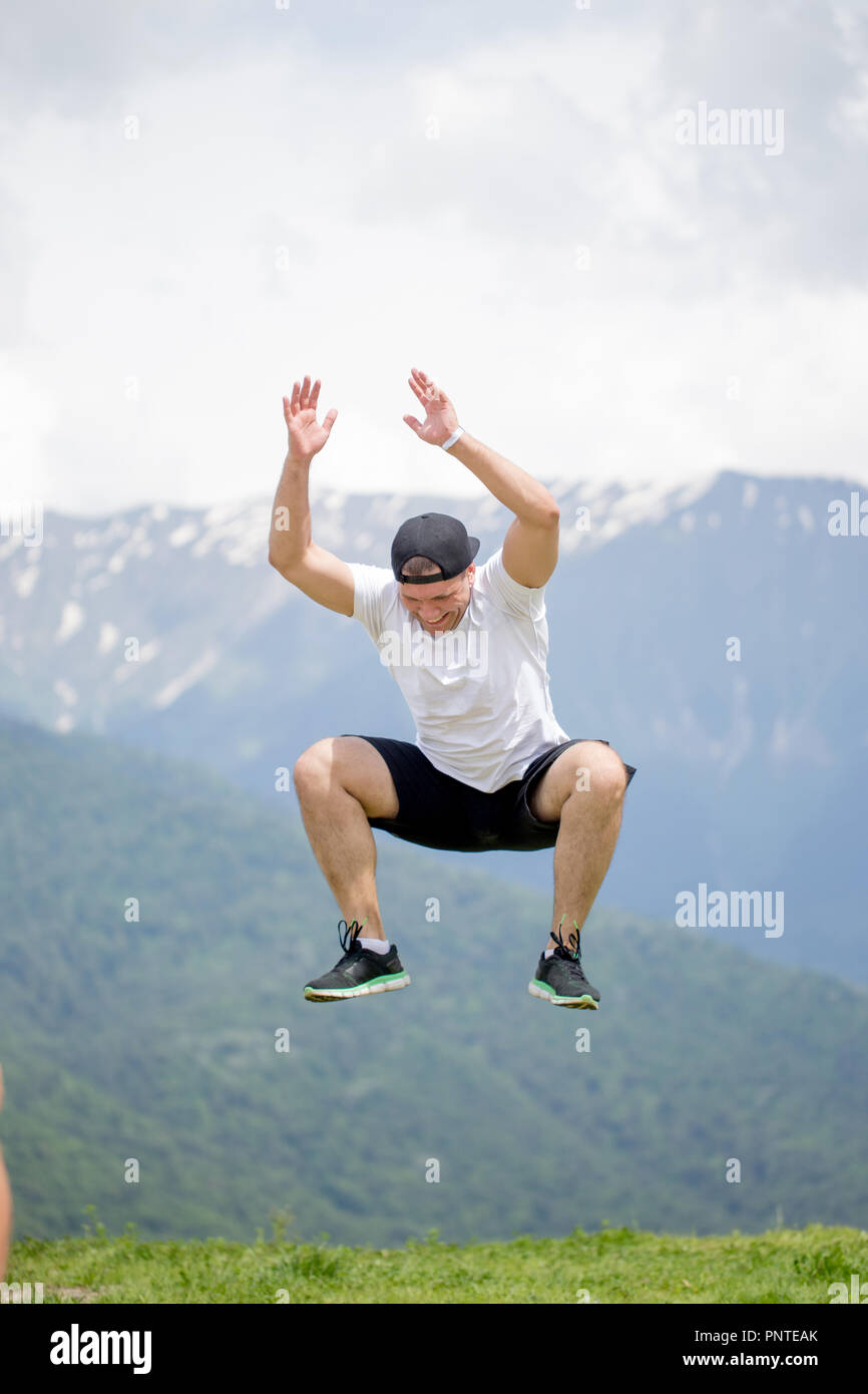 Happy Man jumping at mountains to clouds sky. Lifestyle Travel ...