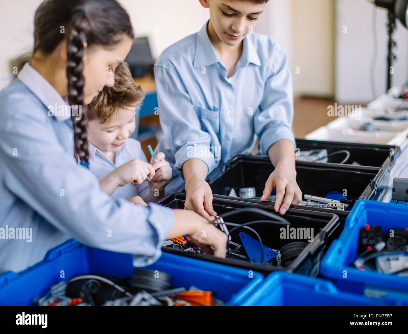 Group of kids choose parts of robotic toys for building robots at ...