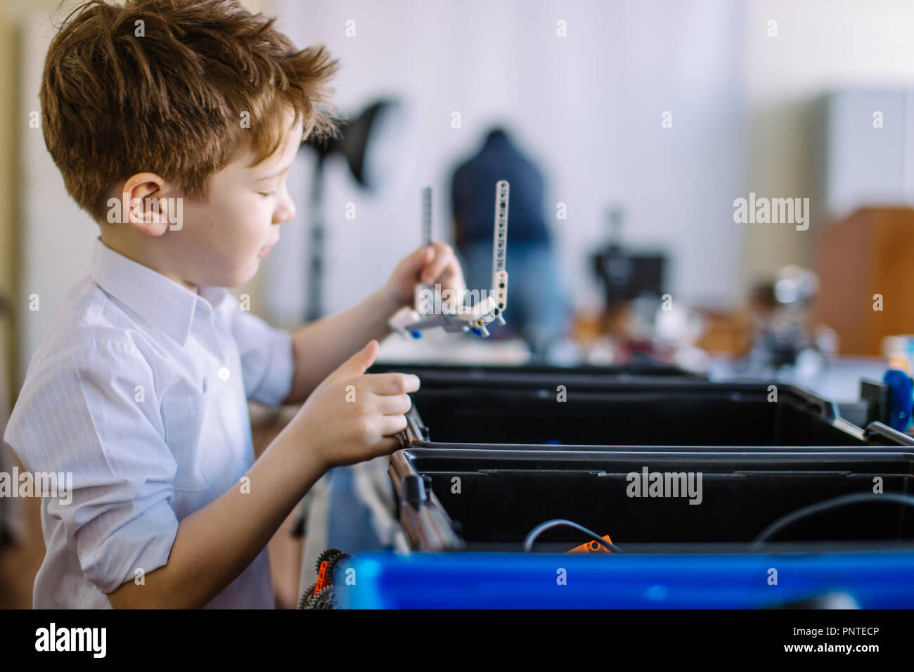 Little boy in robotics school makes robot Stock Photo - Alamy