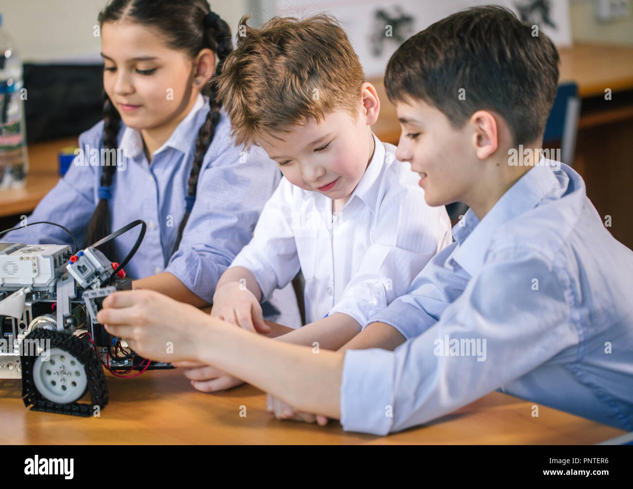Kids playing with electrical robot while visiting robotics exhibition ...