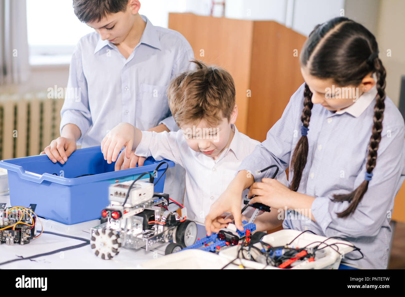 Kids playing with electrical robot while visiting robotics exhibition ...