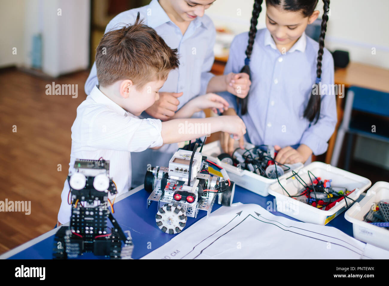 Kids playing with electrical robot while visiting robotics exhibition ...
