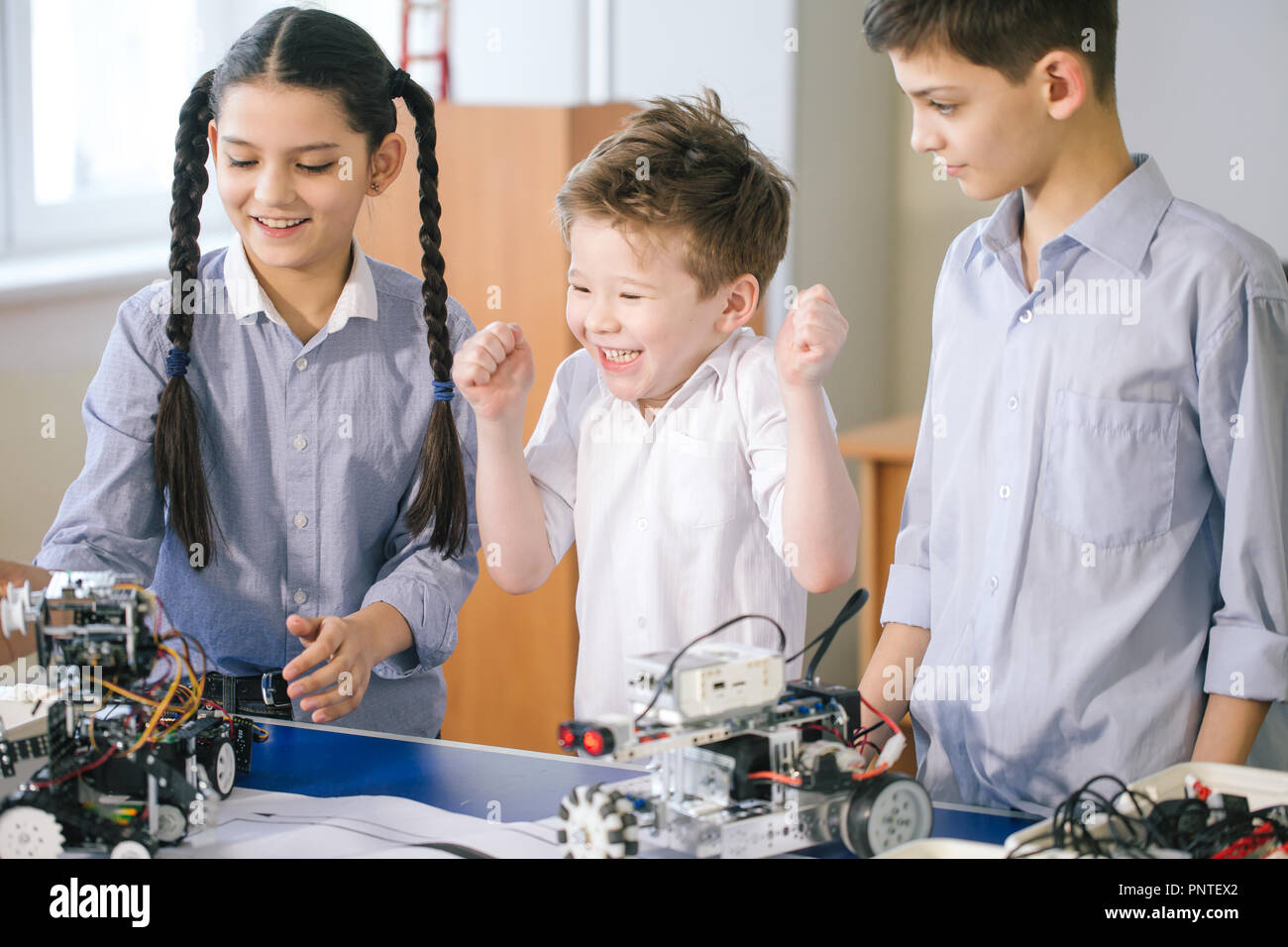 Kids playing with electrical robot while visiting robotics exhibition ...
