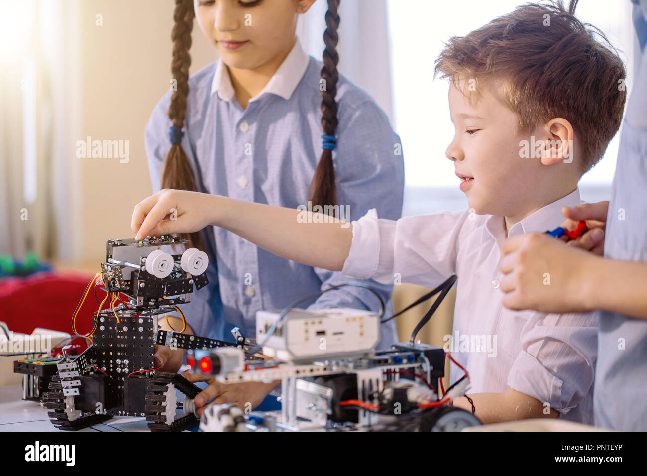 Kids playing with electrical robot while visiting robotics exhibition ...