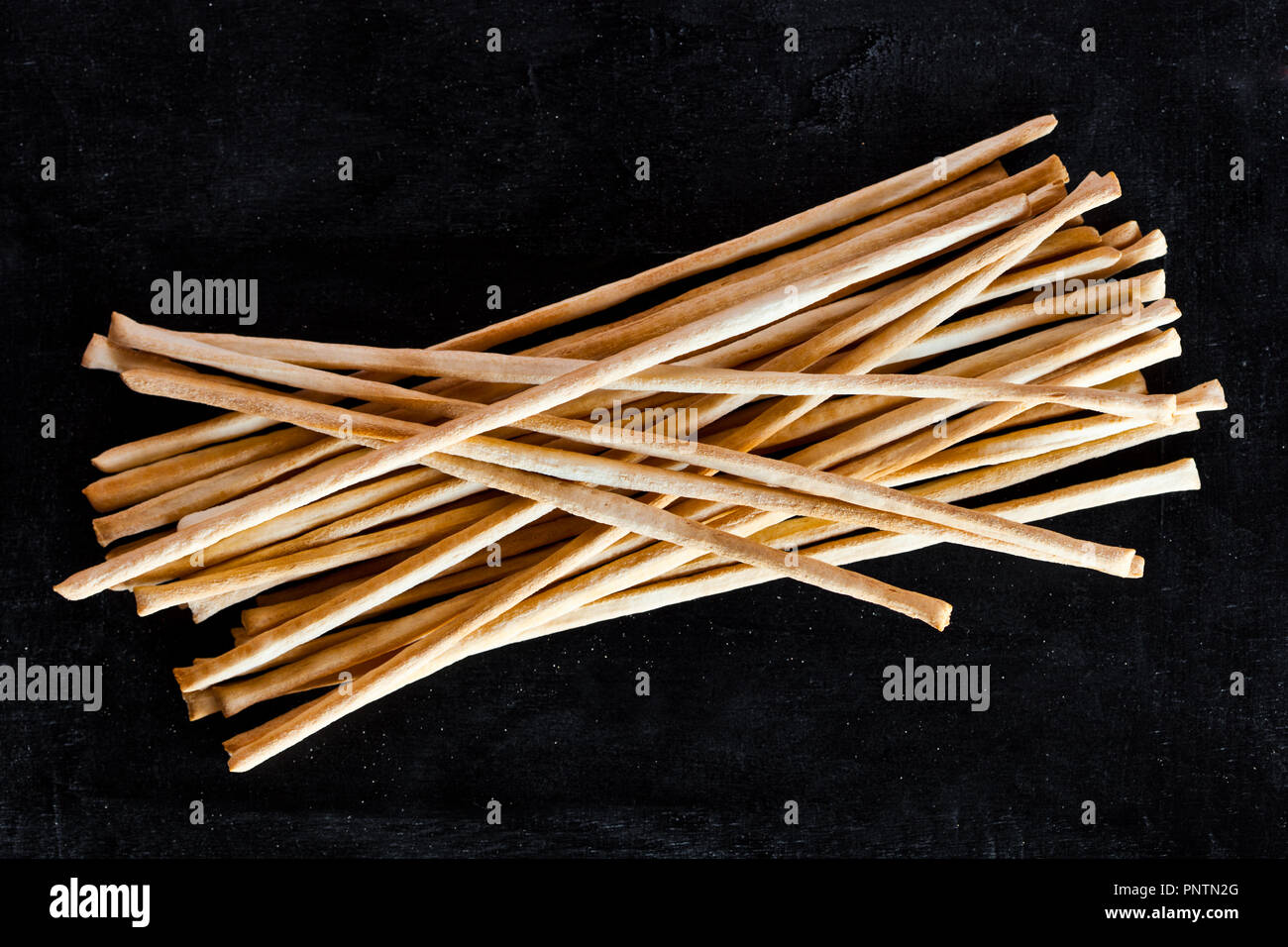 top view of breadsticks grissini torinesi on blackboard background ...