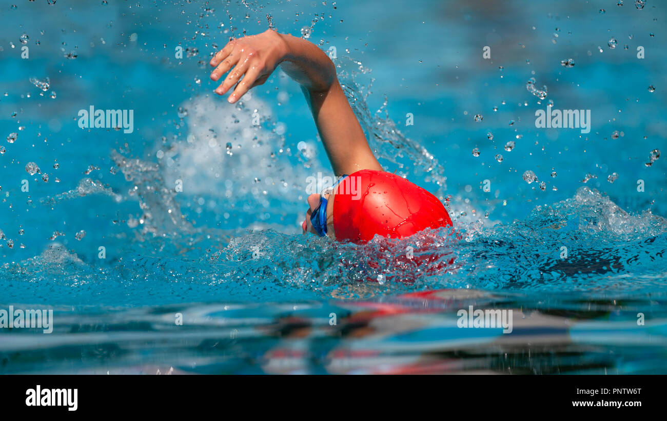 Swimmer with red cap in public swimming pool Stock Photo - Alamy