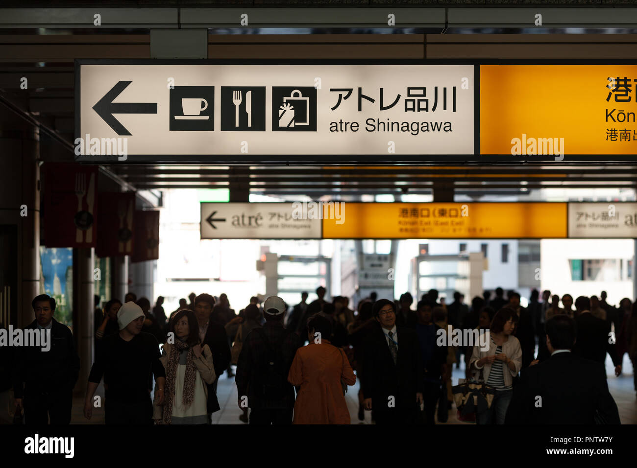 Overhead direction signs above backlit commuters in Tokyo, Japan Stock ...