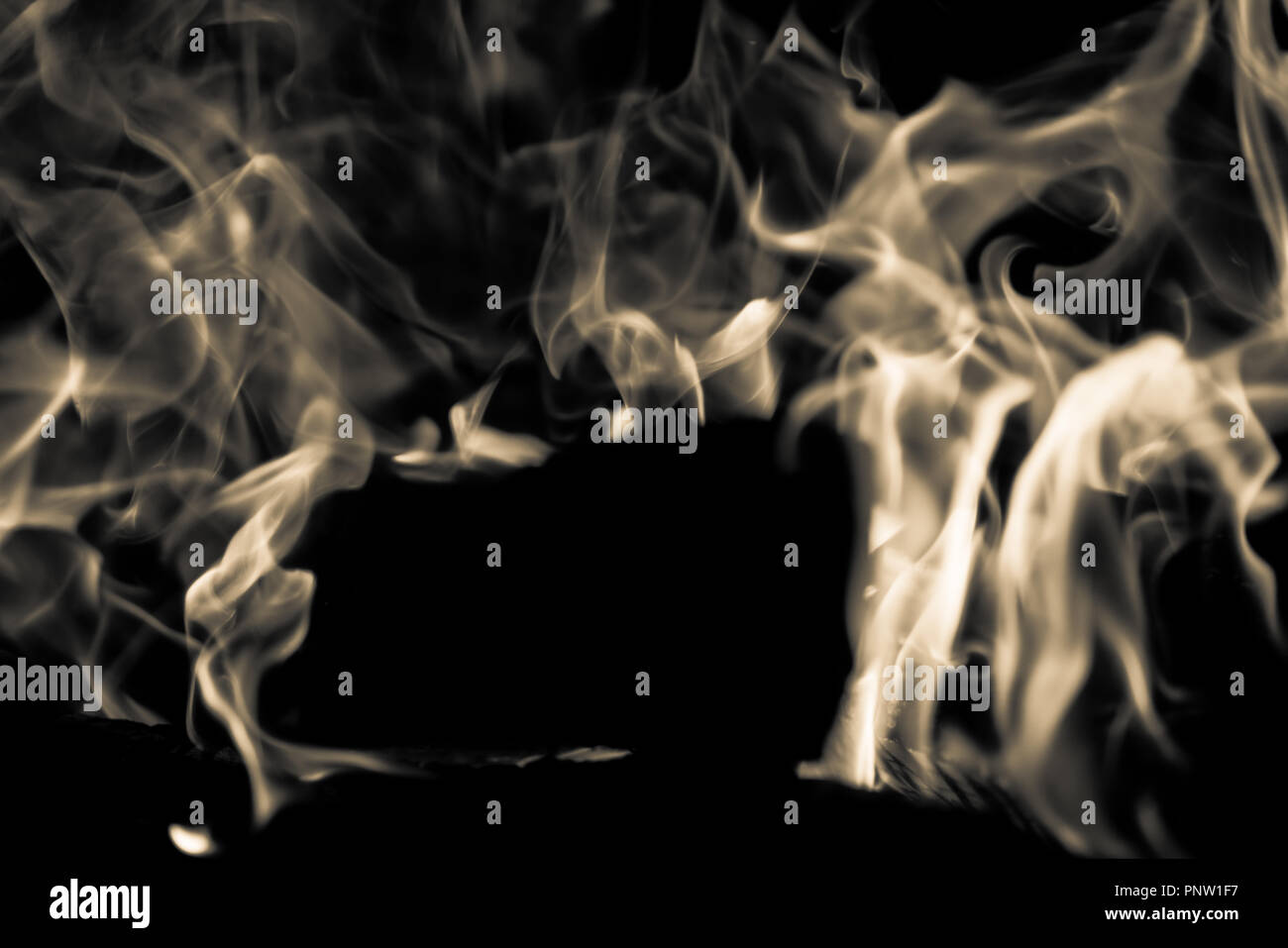 Black and white shot of fire flames and glowing ashes on black ...