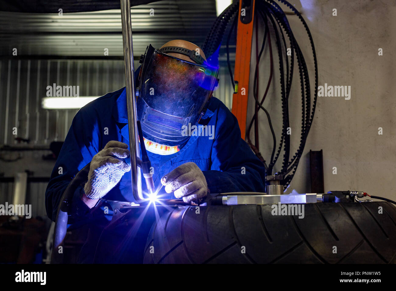 Professional car mechanic working in auto repair service on argon gas ...