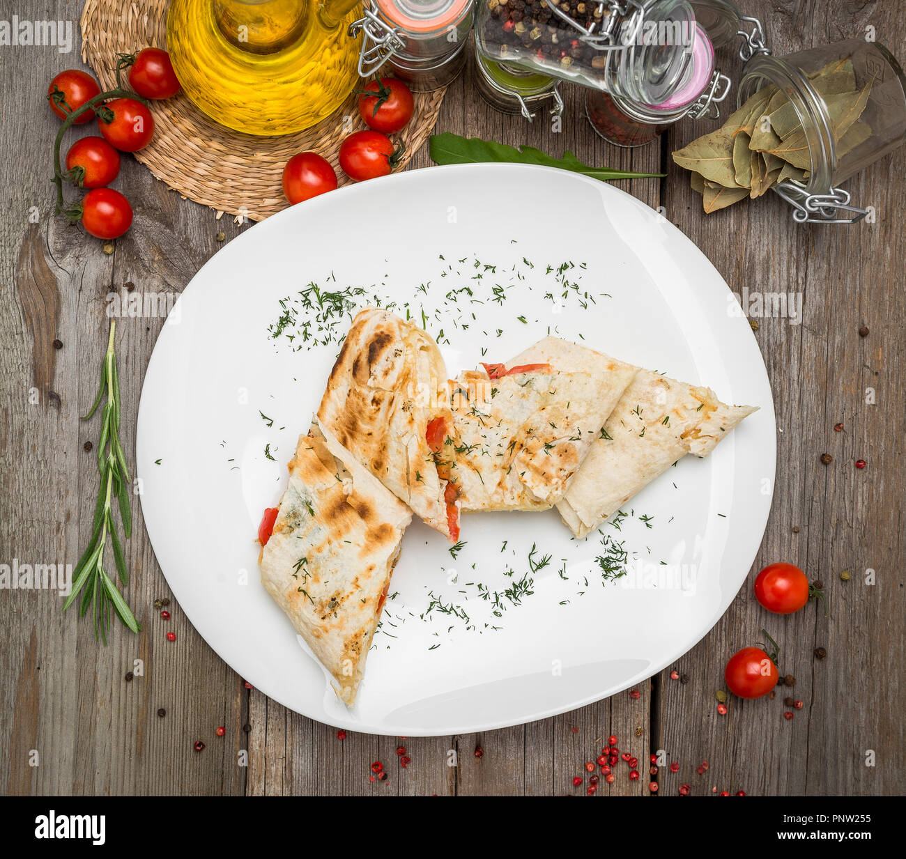 Shawarma sandwich or lavash with fresh vegetables and sauce on the gray ...