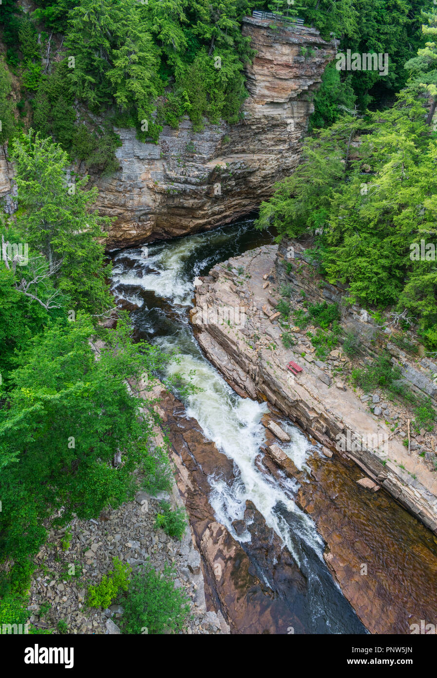 The Ausable River in the summer time flowing over rocks to form rapids ...