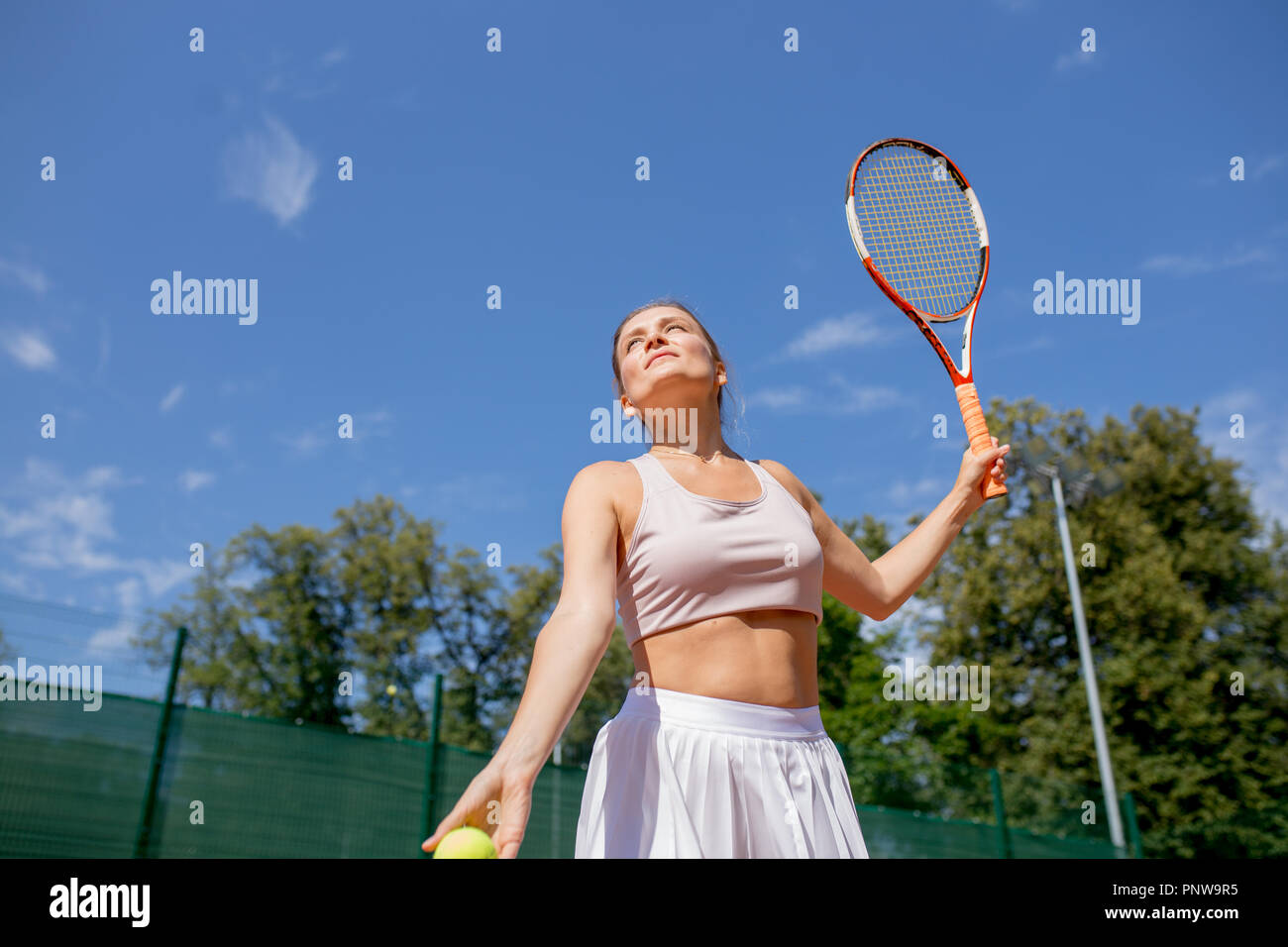 Beautiful female tennis player serving outdoor Stock Photo - Alamy
