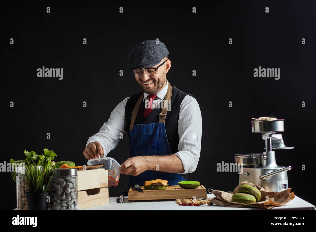 Man cooking green burger with beef, salad and vegetables Stock Photo ...
