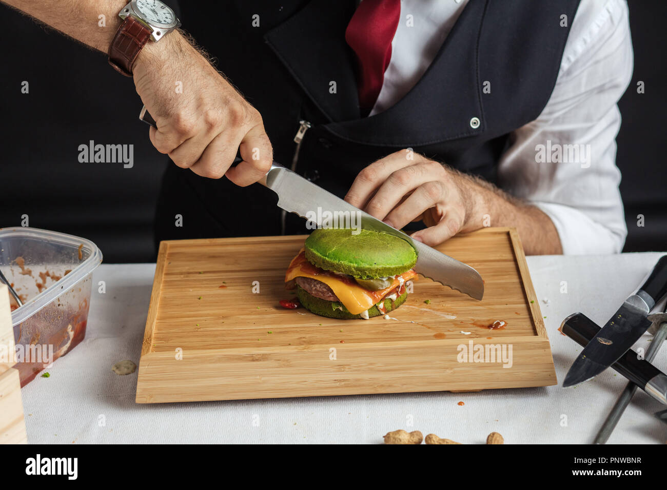 Process of eating burgers. Master Cook cutting tasty hamburger with ...