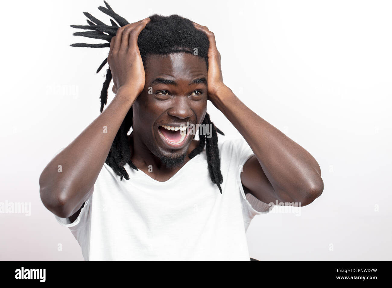 portrait of surprised black man holding head in hands, screaming in ...