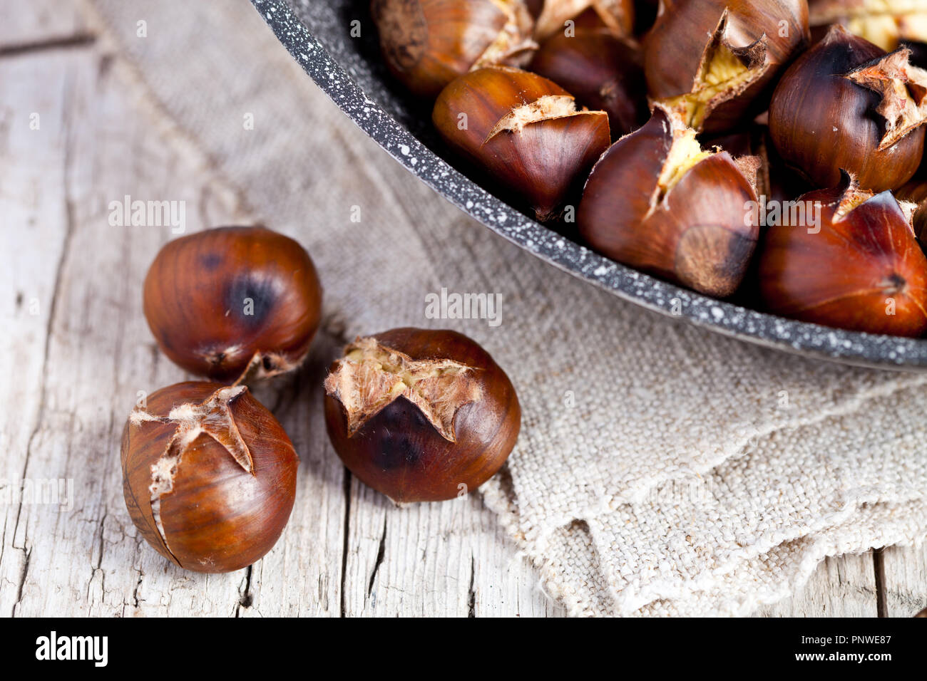 roasted chestnuts in a pan on wooden background Stock Photo - Alamy