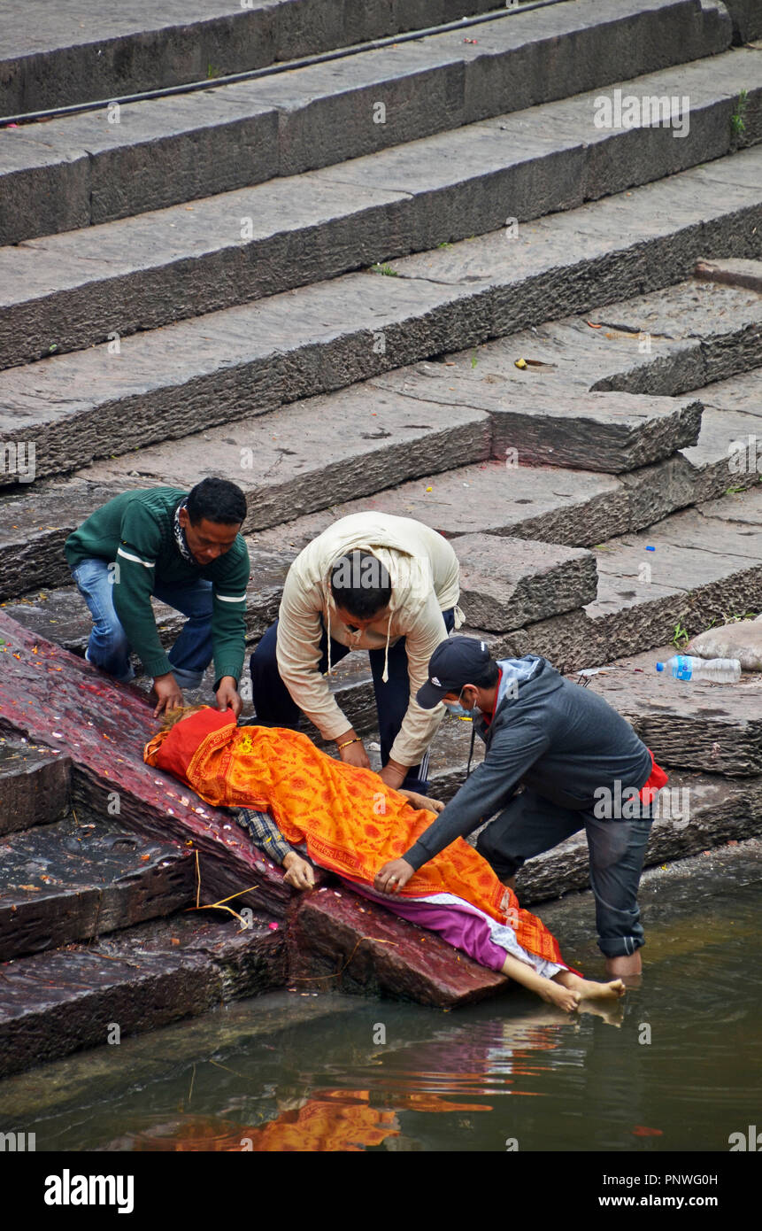 A corpse is preopared for cremation beside the Bagmati River near the ...