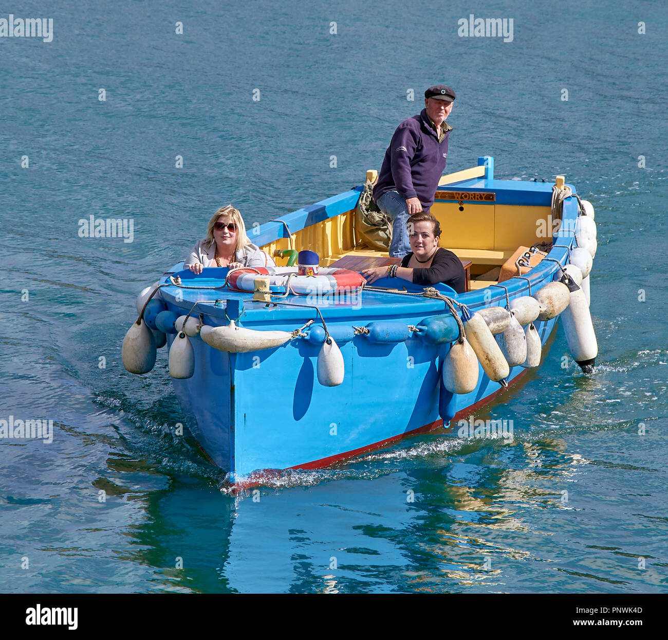 A traditional wooden motor launch (passenger ferry) carrying two female ...