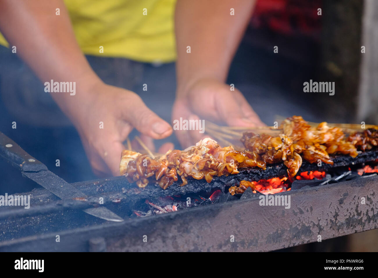 Chicken satay cooking on a tradition open coal barbecue Stock Photo - Alamy