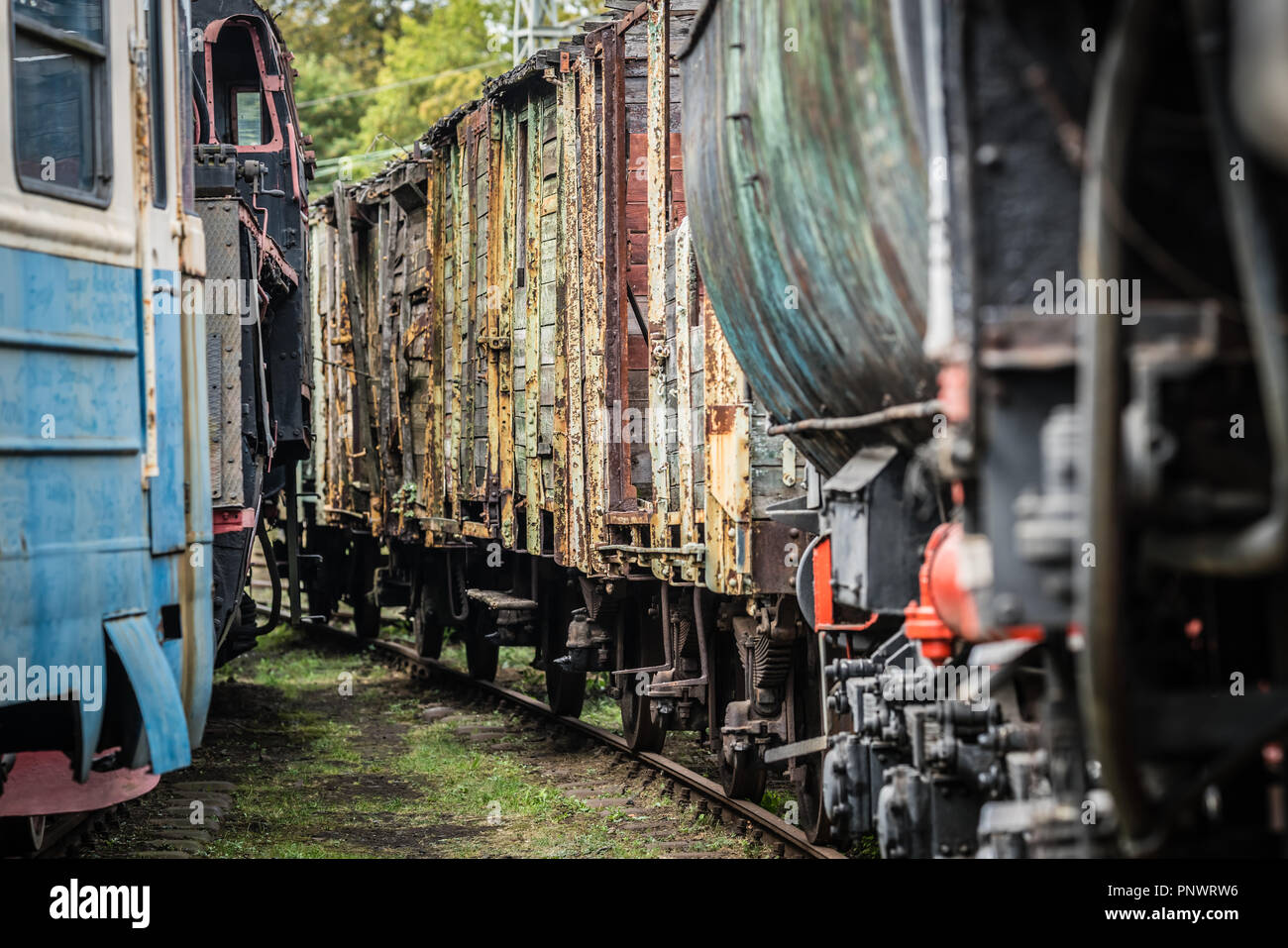 An old disused retro freight train wagons and cars on the side track ...