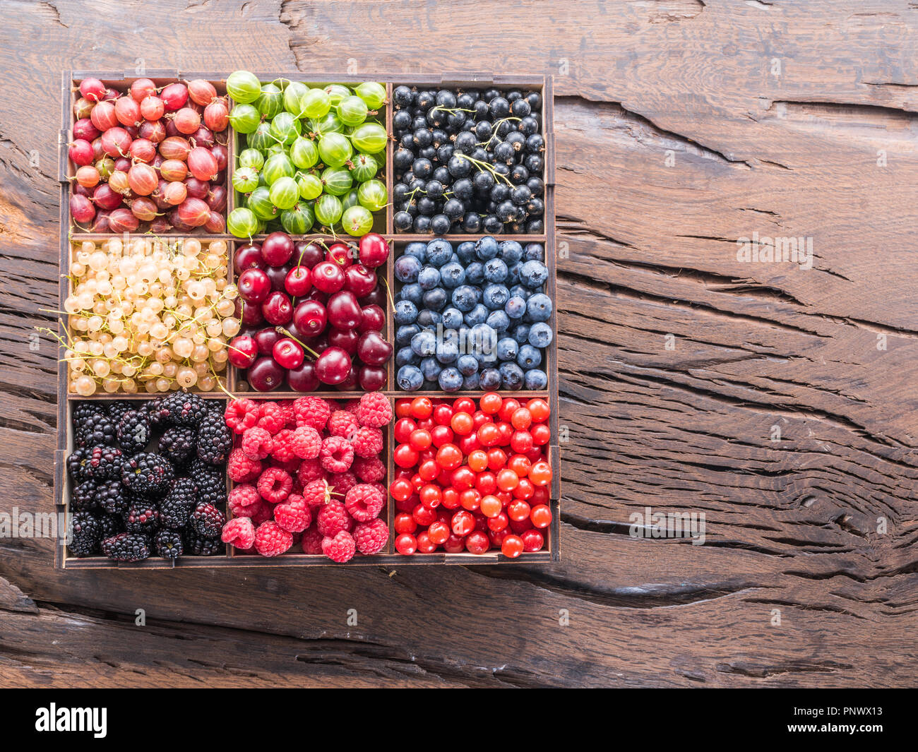 Colorful berries in wooden box on the table. Top view Stock Photo - Alamy