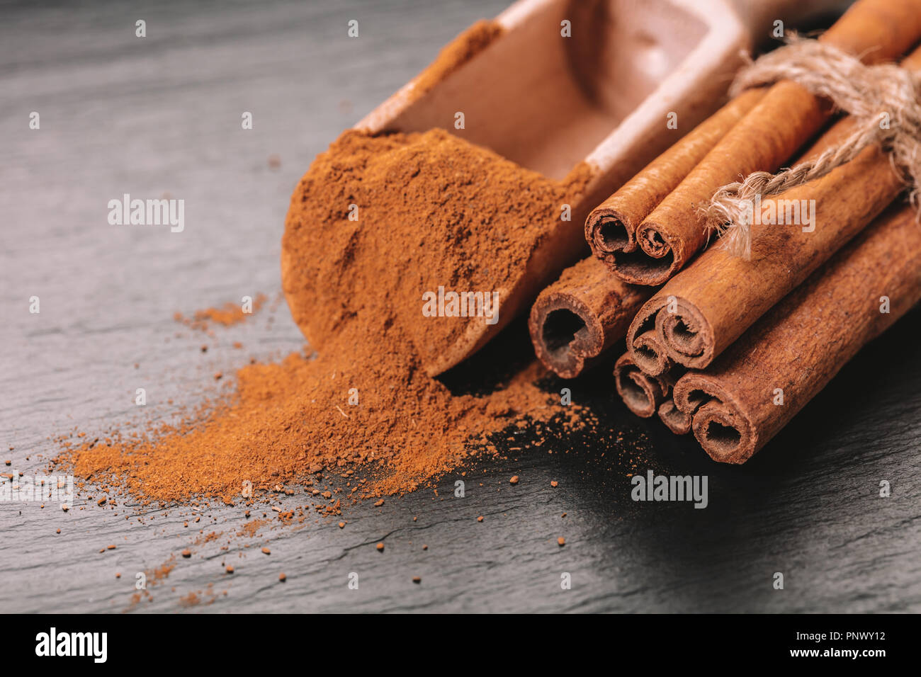 spice cinnamon close-up on a black stone background Stock Photo - Alamy
