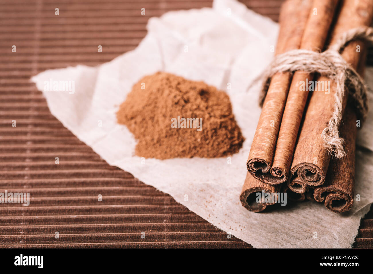 dry spice cinnamon closeup on brown background Stock Photo - Alamy