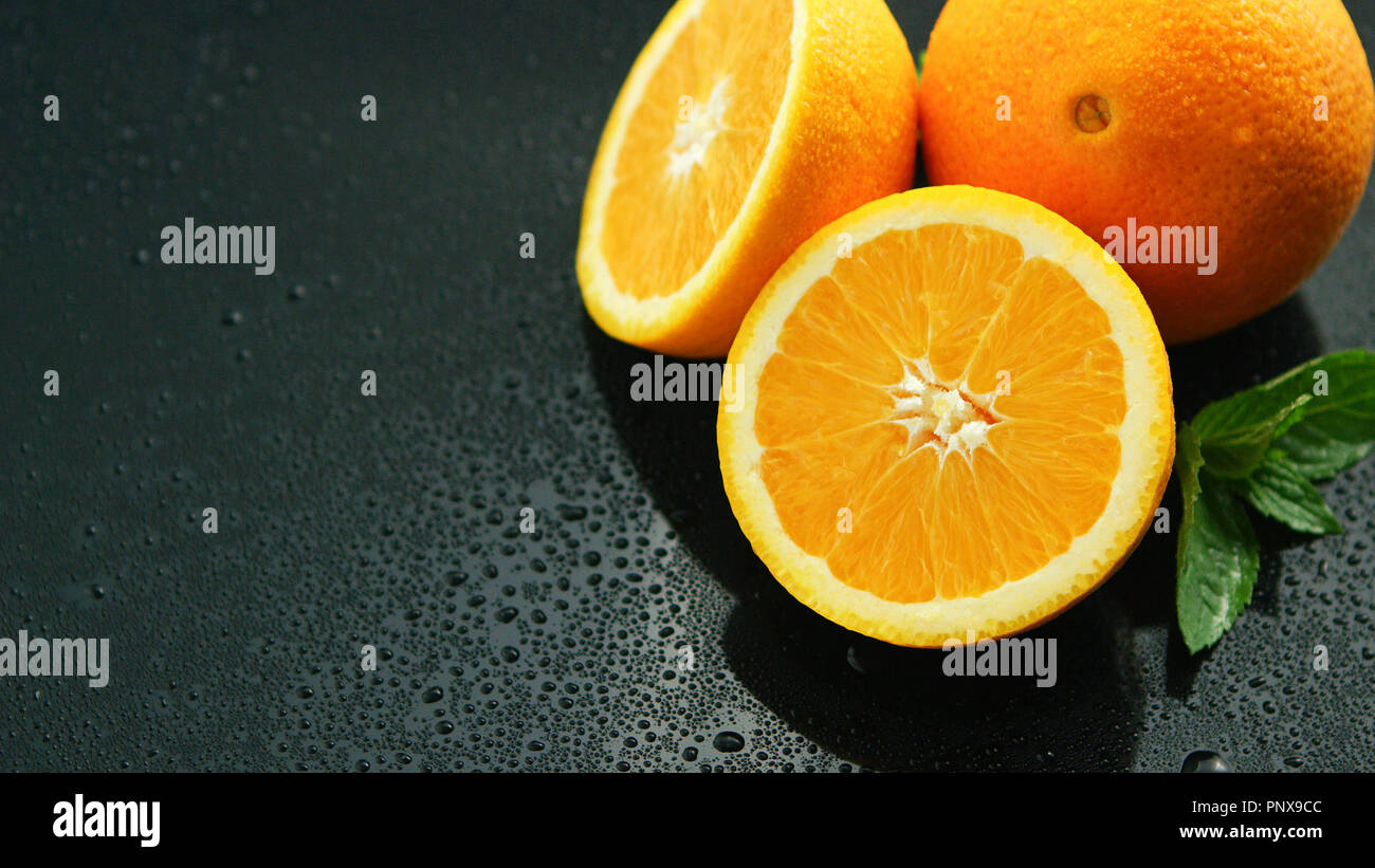 Orange with leaf on wet table Stock Photo - Alamy