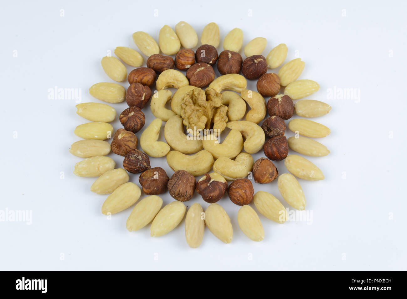 Mixed nuts ordered in flower or sun shape Stock Photo - Alamy