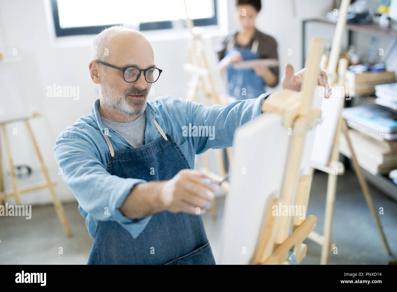 Mature painter concentrating on sketching on paper sheet before ...