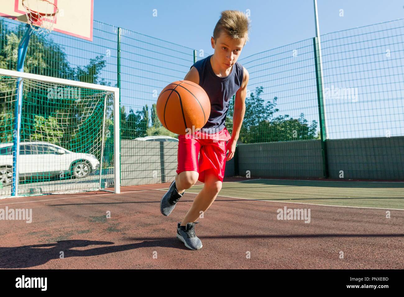 Outdoor portrait street basketball player playing with the ball on ...
