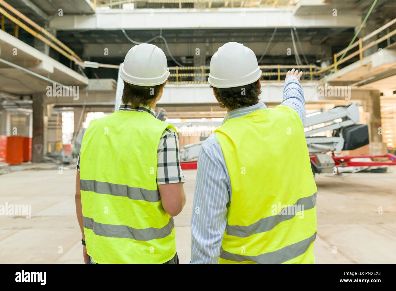 Male construction worker and engineer at the construction site ...