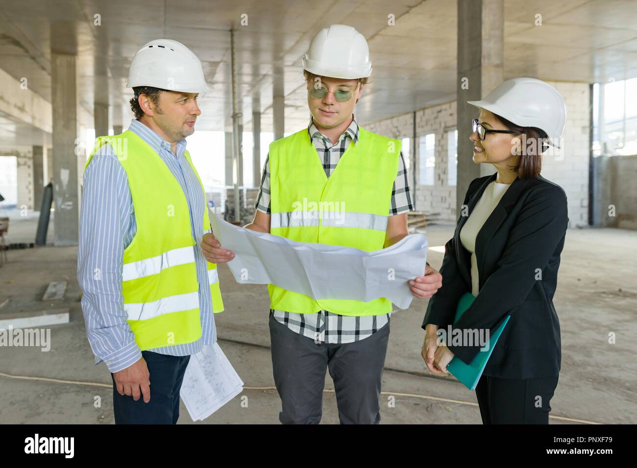 Group of engineers, builders, architects on the building site ...