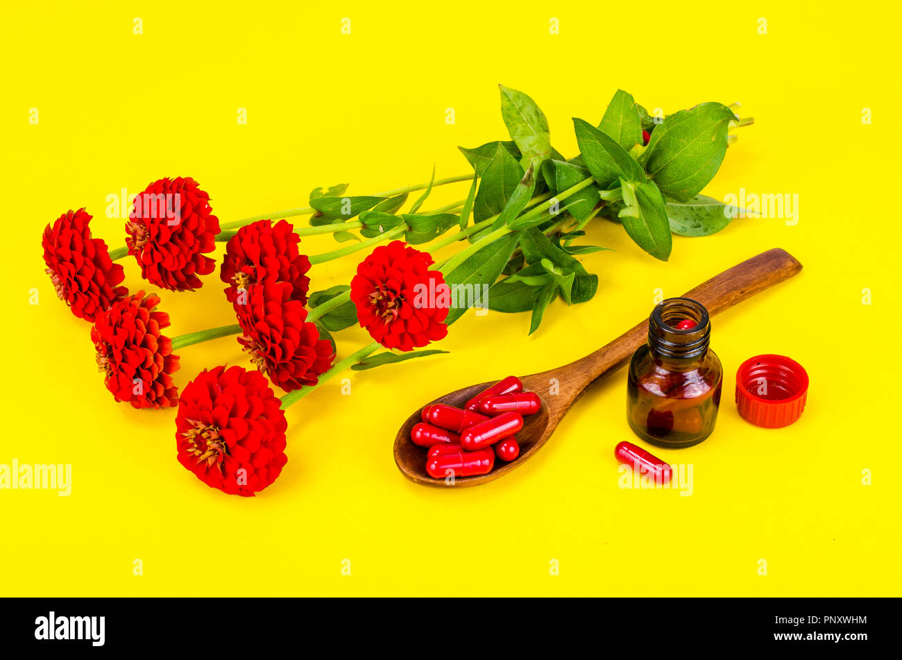 Medical herbal capsules of red color on bright background, alternative ...