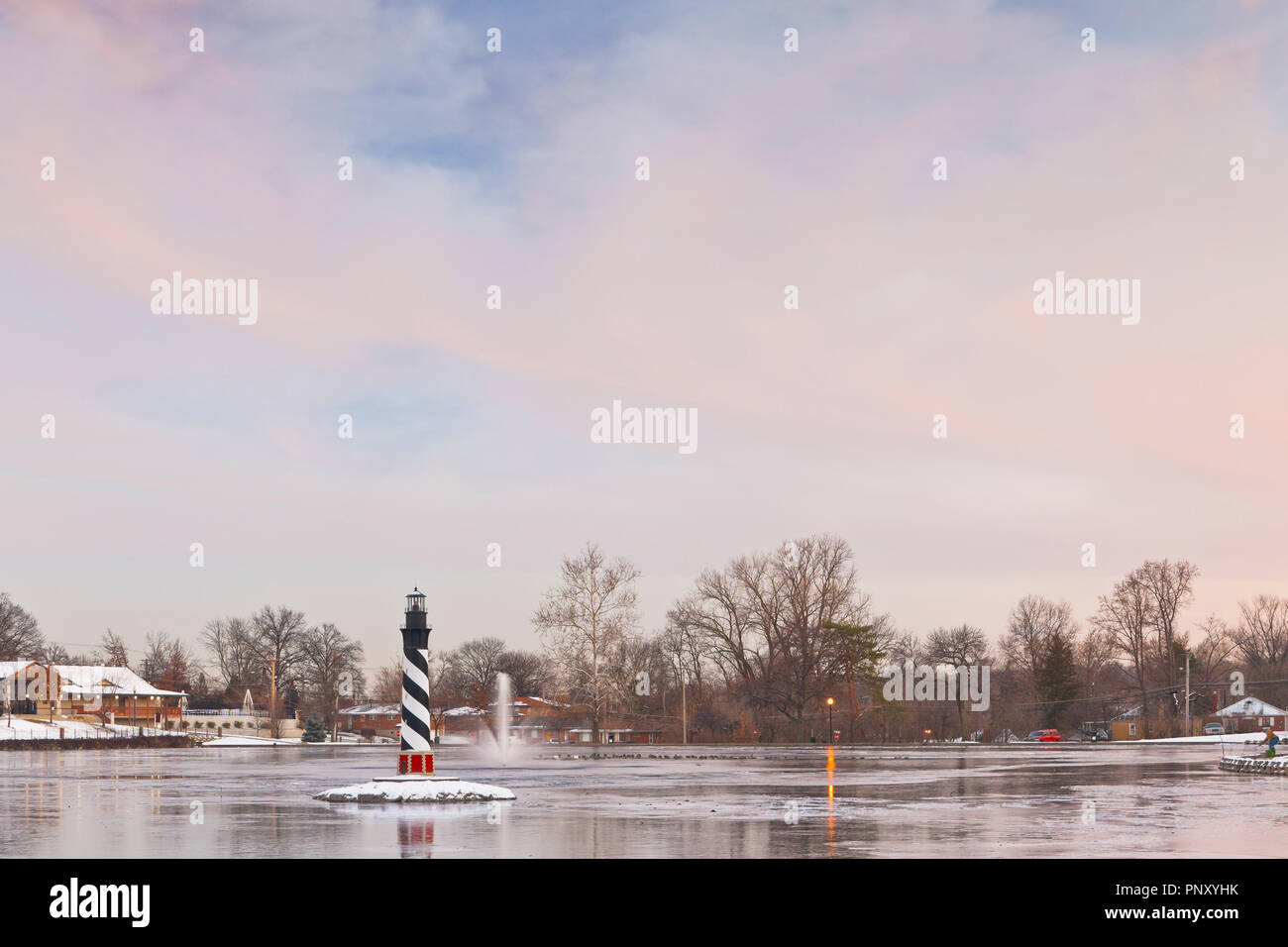 Winter sunset over lighthouse and fountain in the lake at January ...