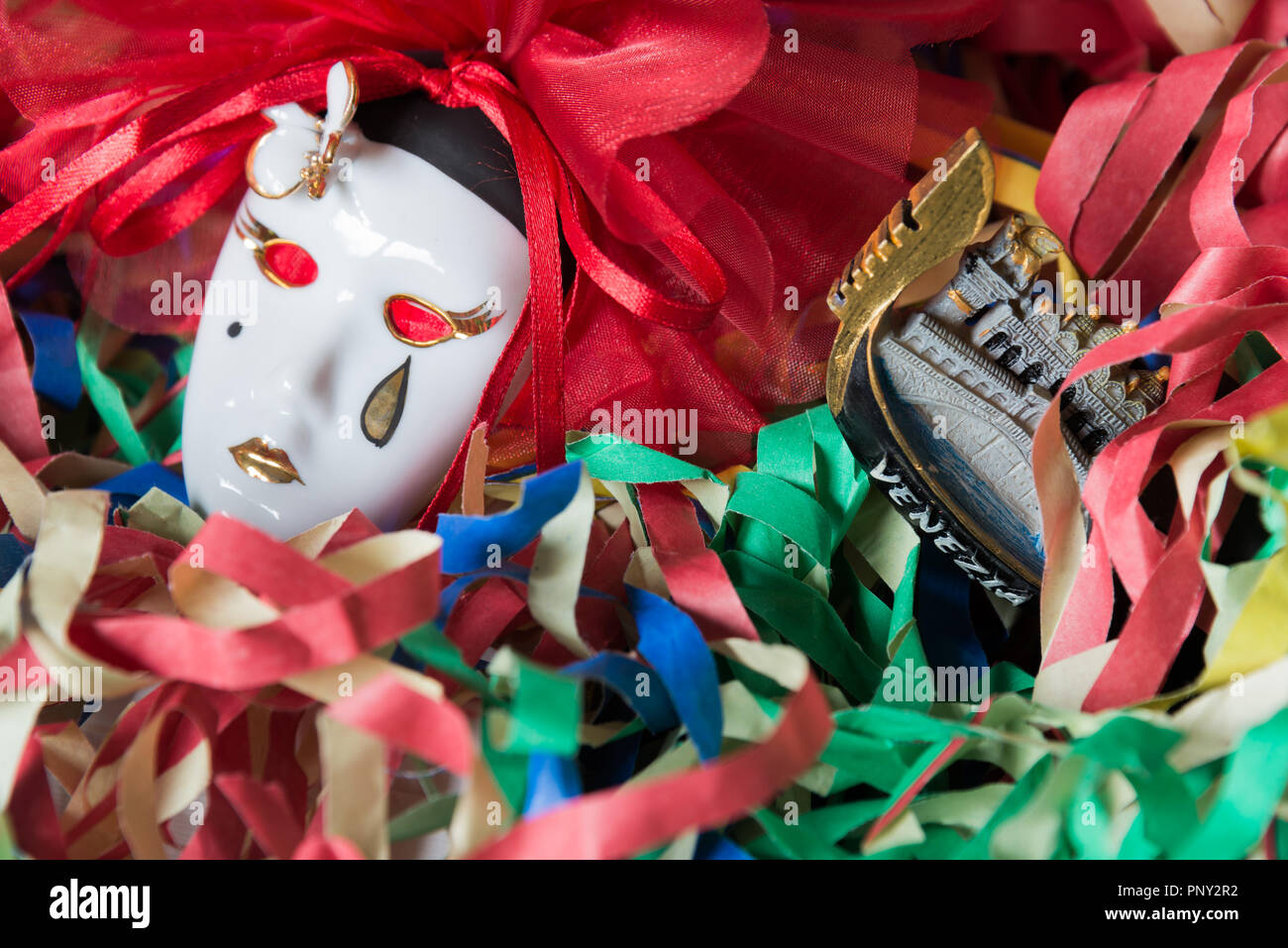 Close-up of Pierrot carnival mask on a background of colored streamers ...