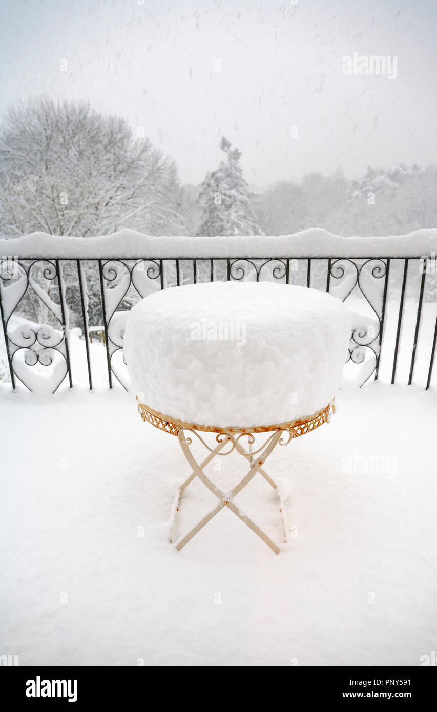 Metal table of a garden furniture patio set covered in deep snow in ...