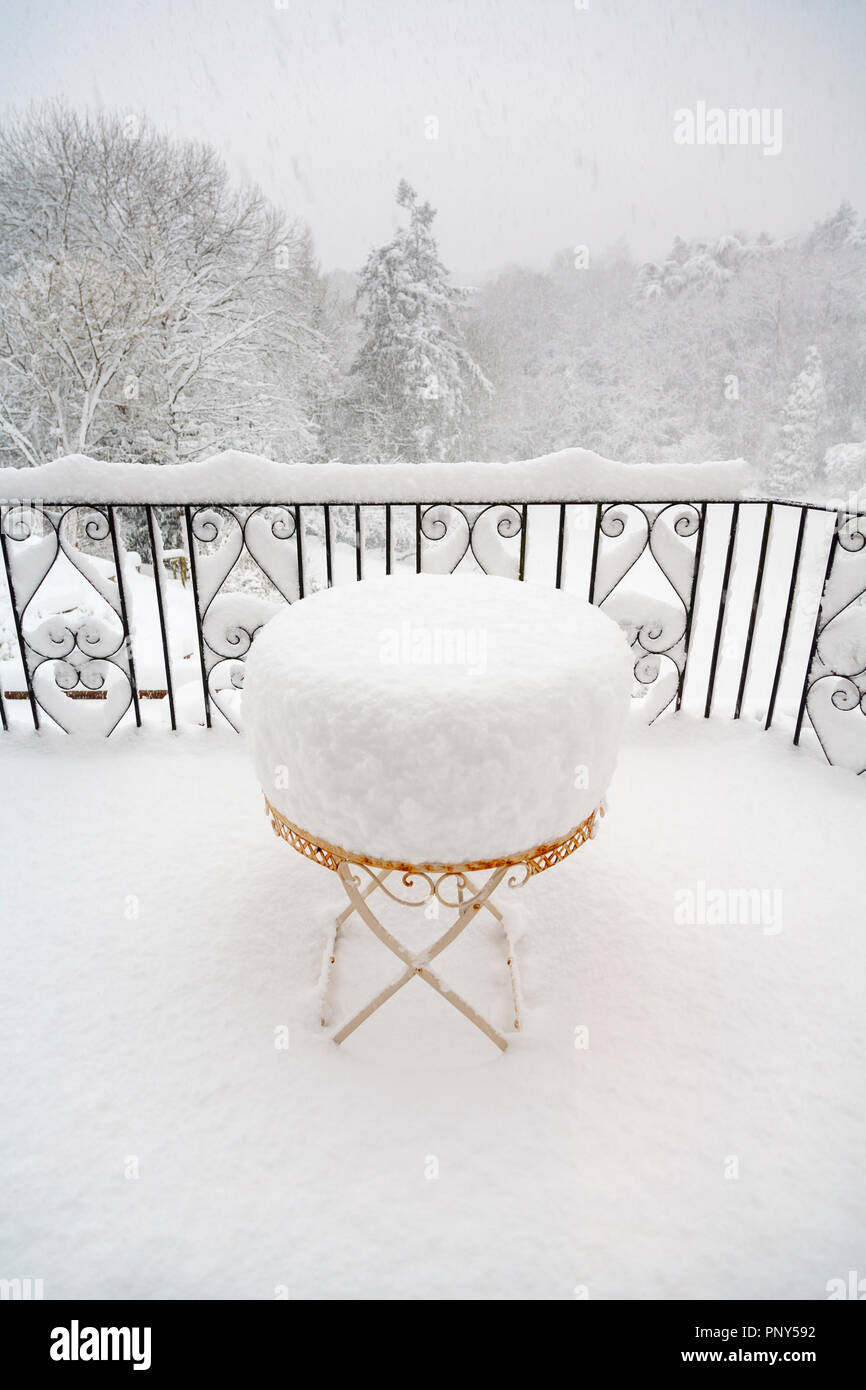 Metal table of a garden furniture patio set covered in deep snow in ...