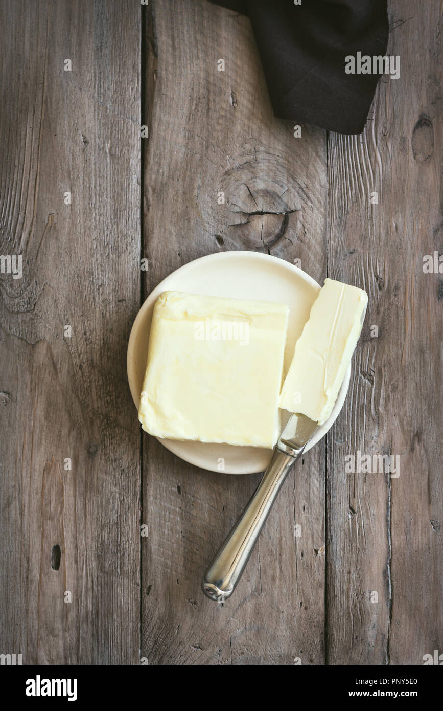 Butter on dark wooden background, copy space. Farm dairy organic ...