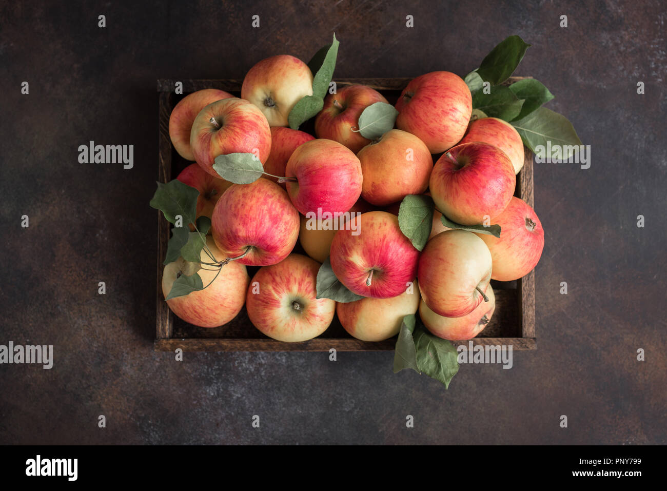 Red apples in wooden box. Organic red apples with leaves on rustic ...