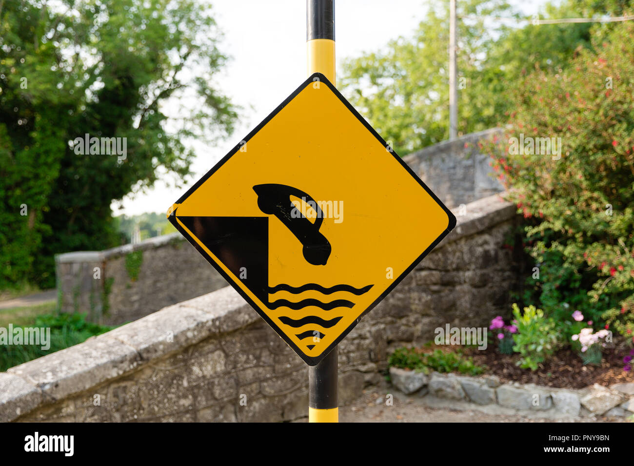 Car falling into the water warning yellow sign at the Grand Canal ...