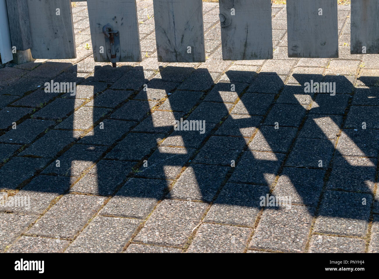 Fence shadows on the tiled ground Stock Photo - Alamy