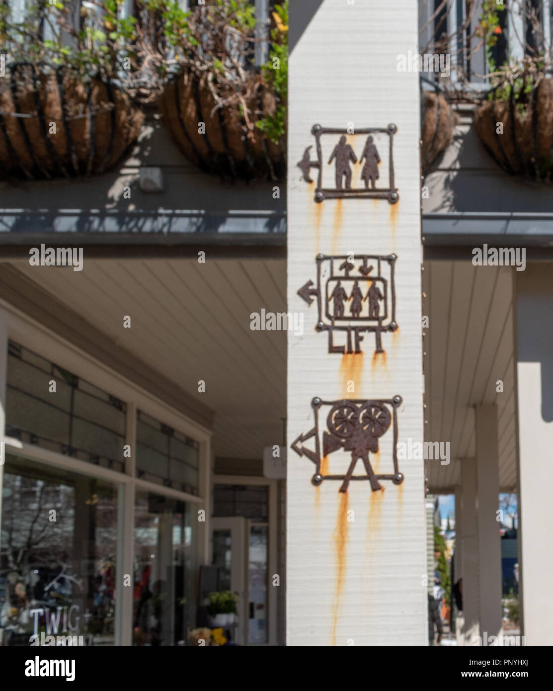 Old rusty metal toilet signs on a wooden post in an outdoor area Stock ...