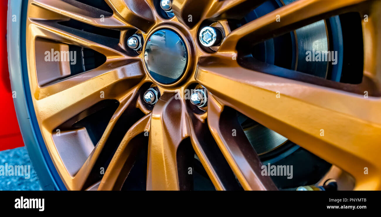 Golden tire rim with disc break showing through Stock Photo - Alamy