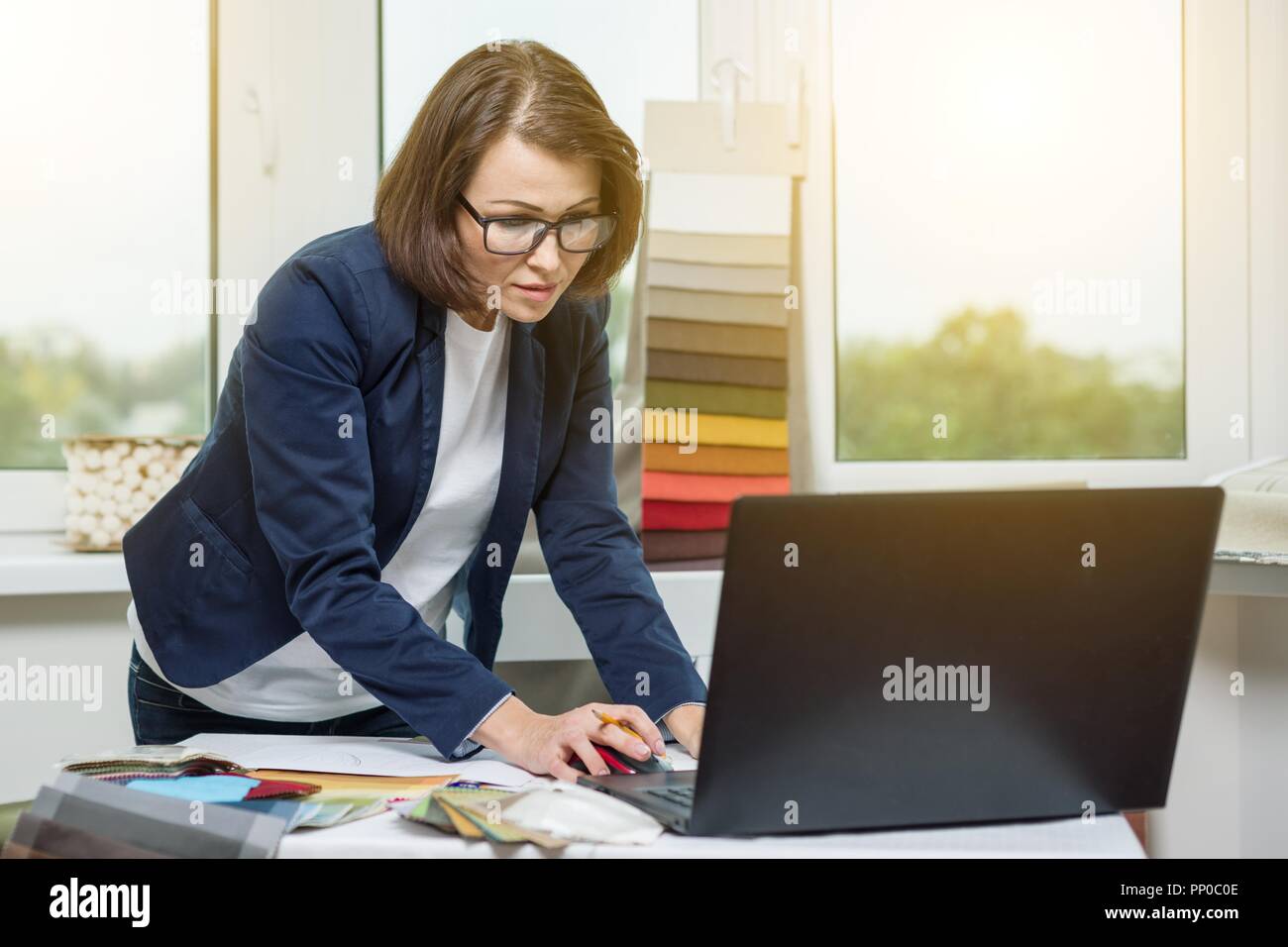 The interior designer, at the workplace in the office, communicates ...