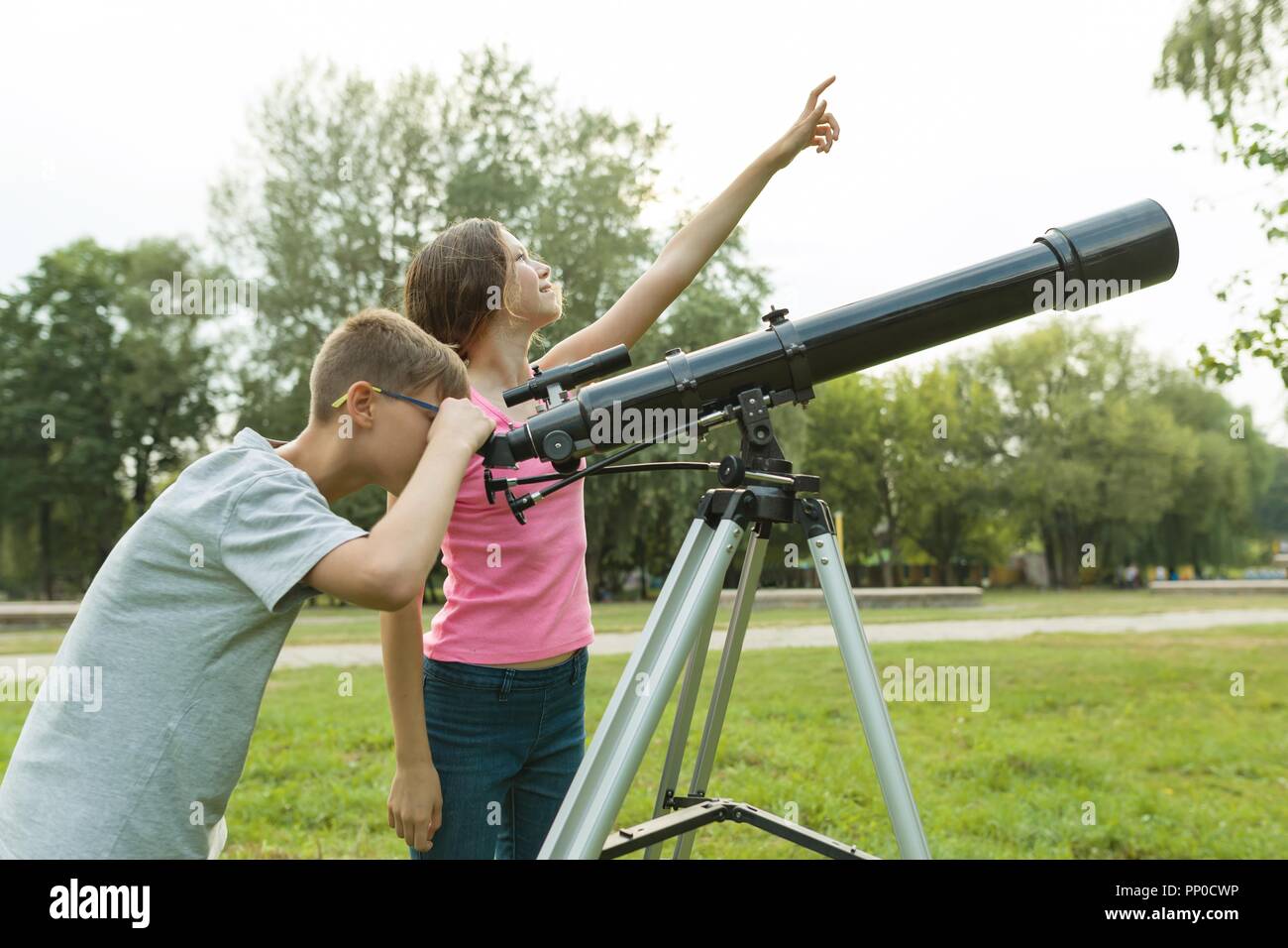 Children teenagers with telescope look at the sky in nature Stock Photo ...
