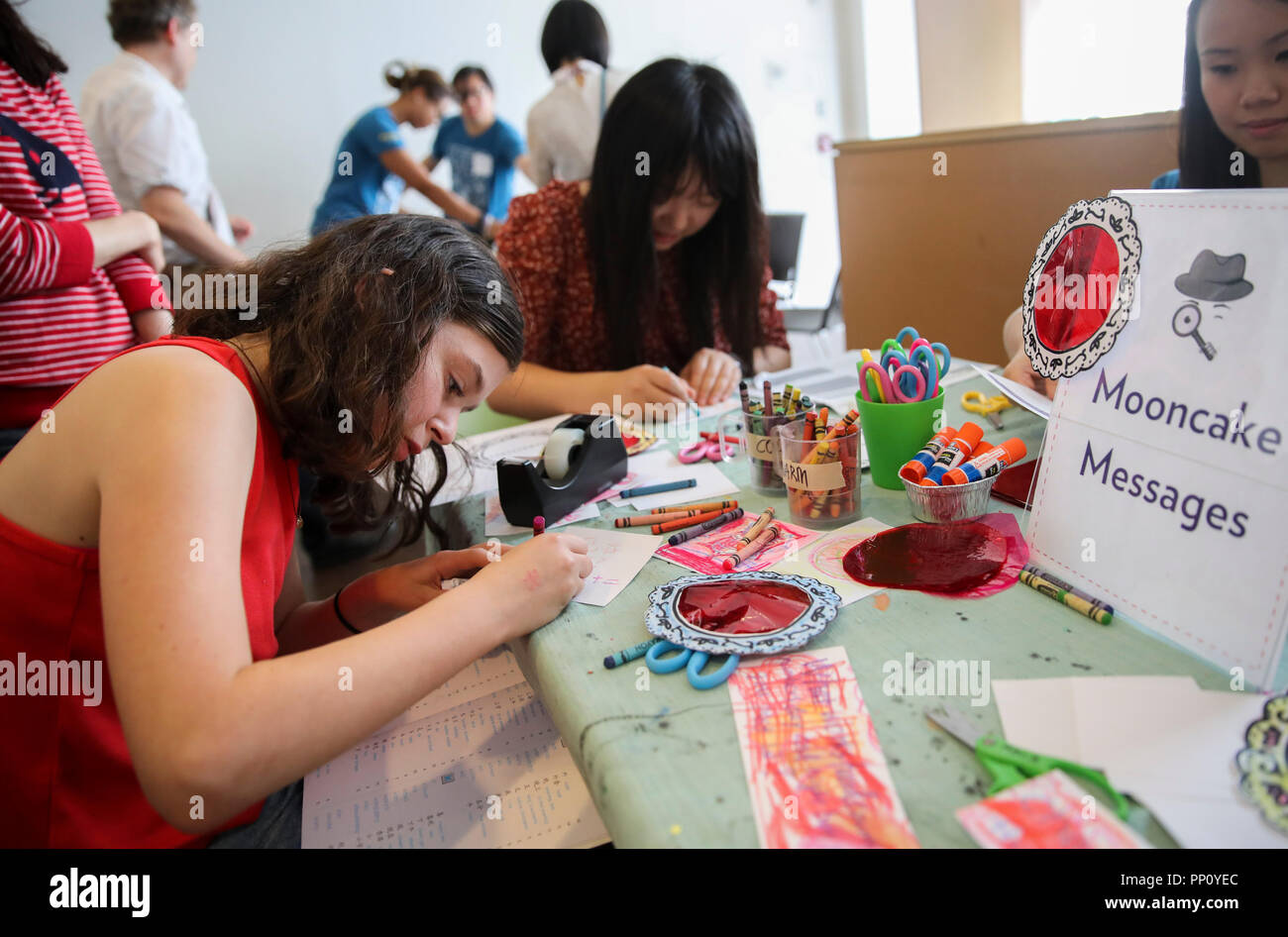 New York, USA. 22nd Sep, 2018. Children write mooncake messages during ...